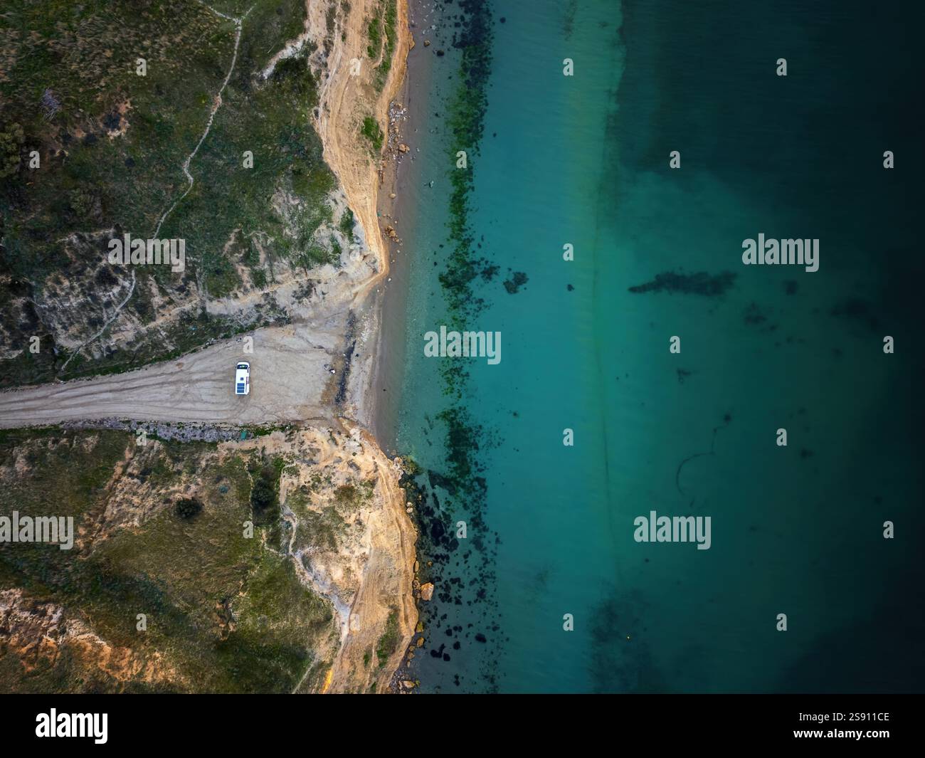 Drone aerial top view of a camper van with solar panels on the beach ...