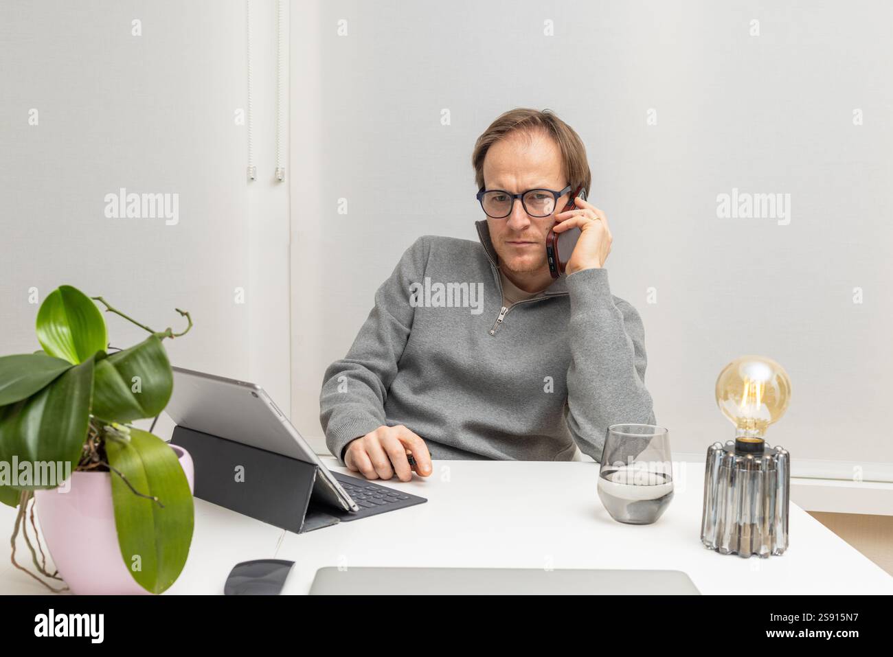 Man tablet taking phone call hi-res stock photography and images - Alamy