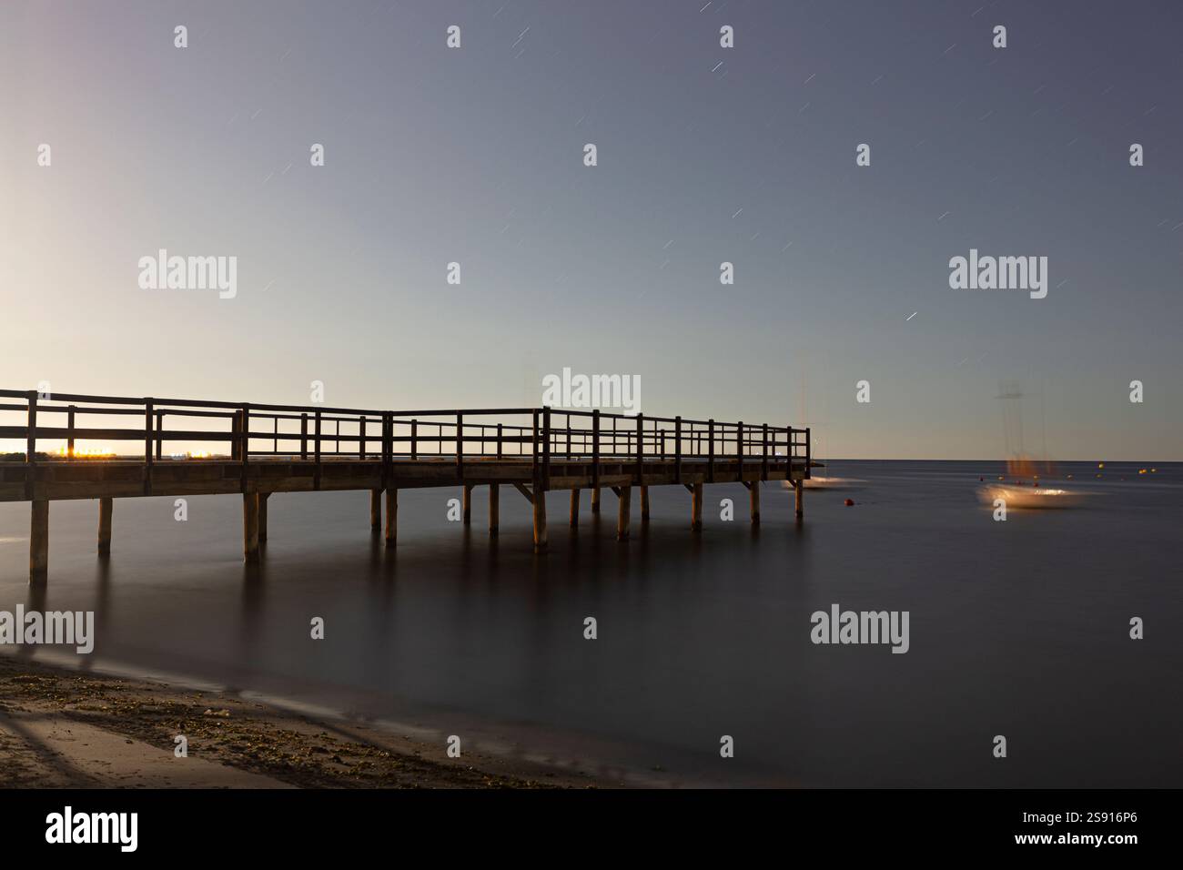 Wooden jetty over the sea with silk effect on a starry summer ni Stock ...