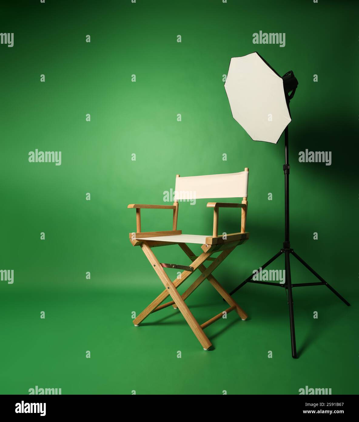 Photo studio with green screen background and wooden stool against ...