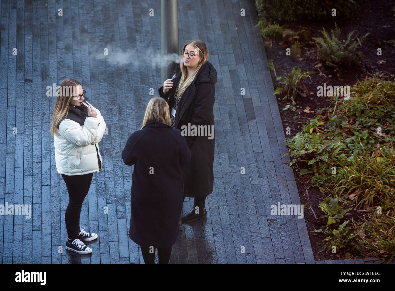 Three women vaping outside a office in central London, England , UK ...