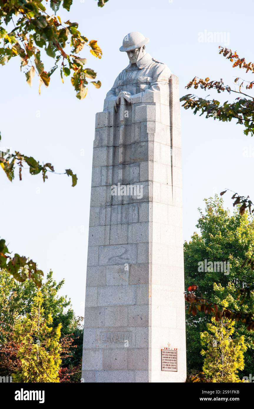 A gray stone monument, likely a war memorial, depicts a soldier in a ...