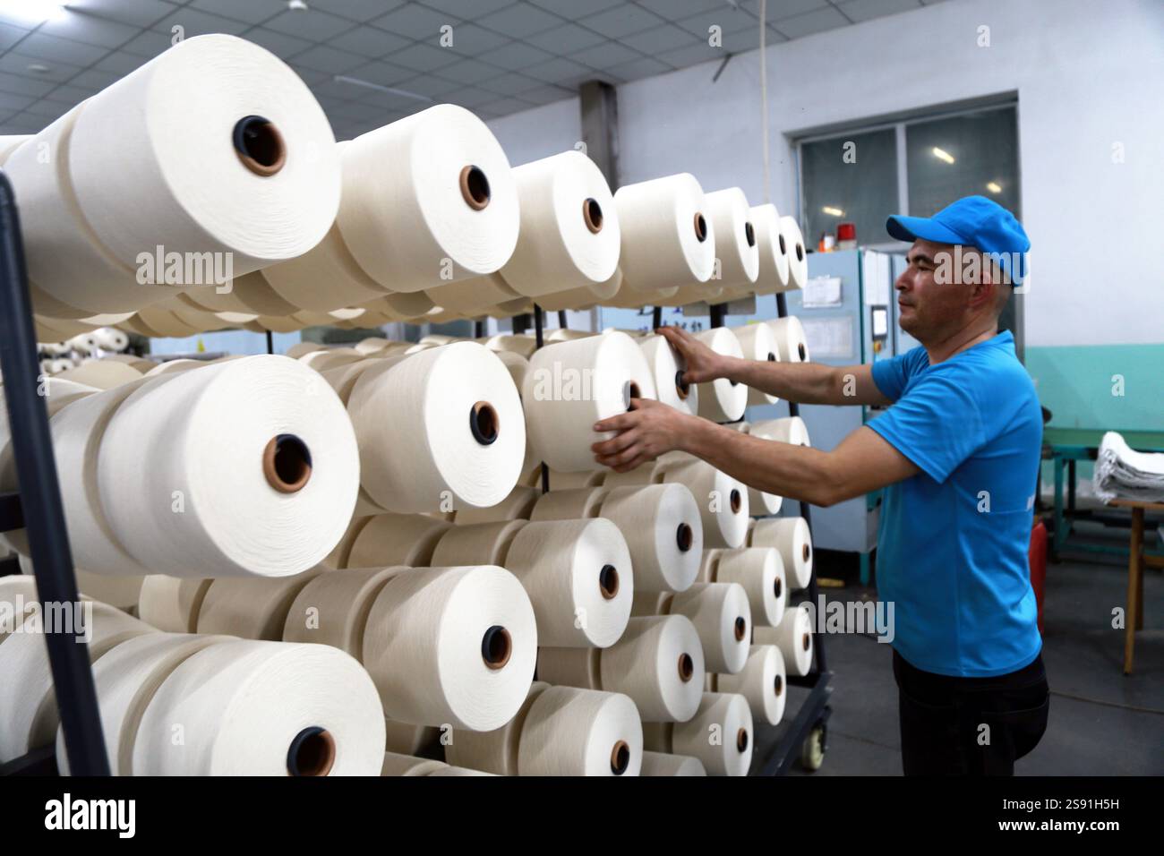 A worker is working at a textile workshop of Xinjiang Jingyi Textile ...