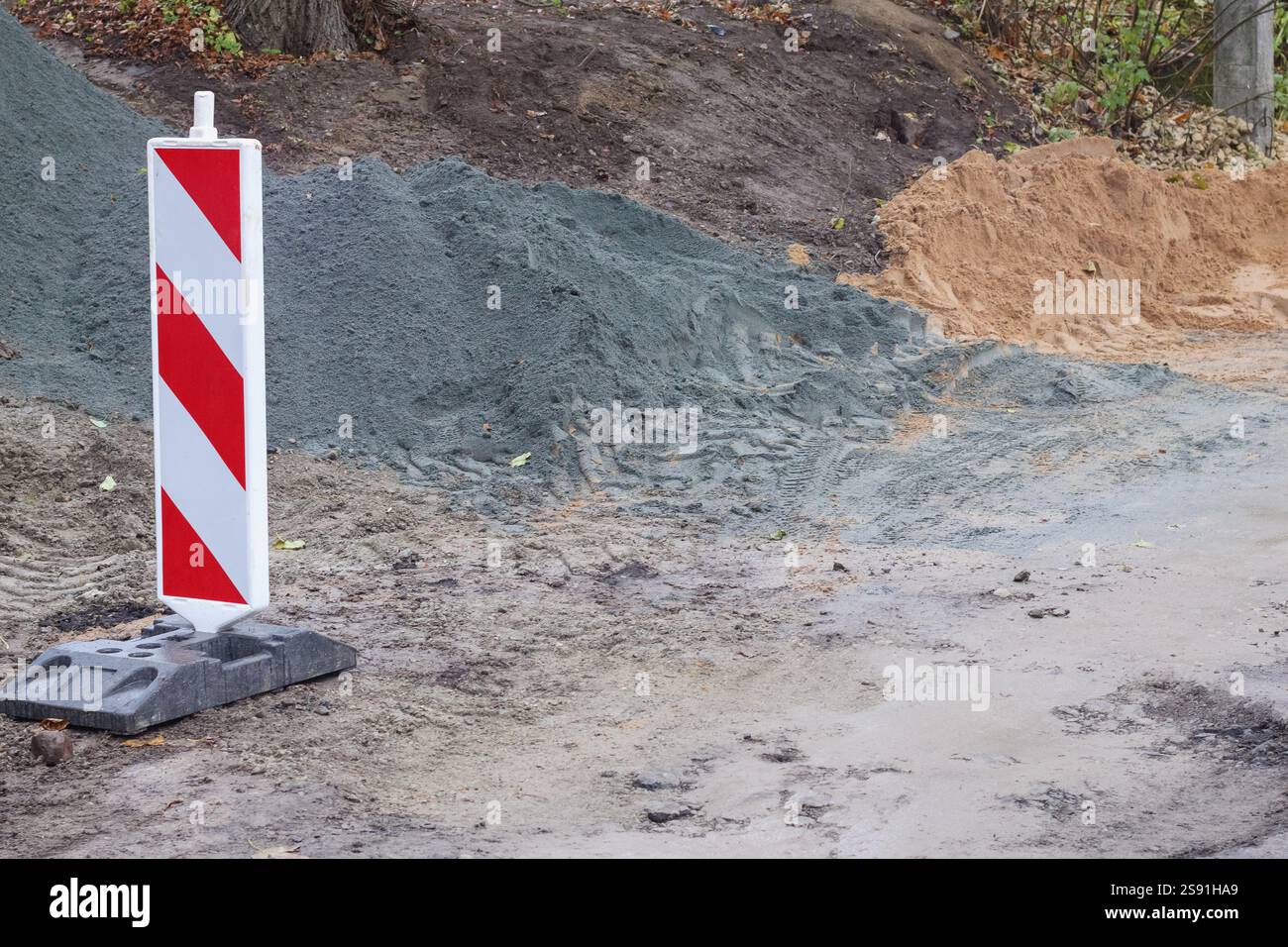 A road, on the side of which a red and white barrier is installed ...