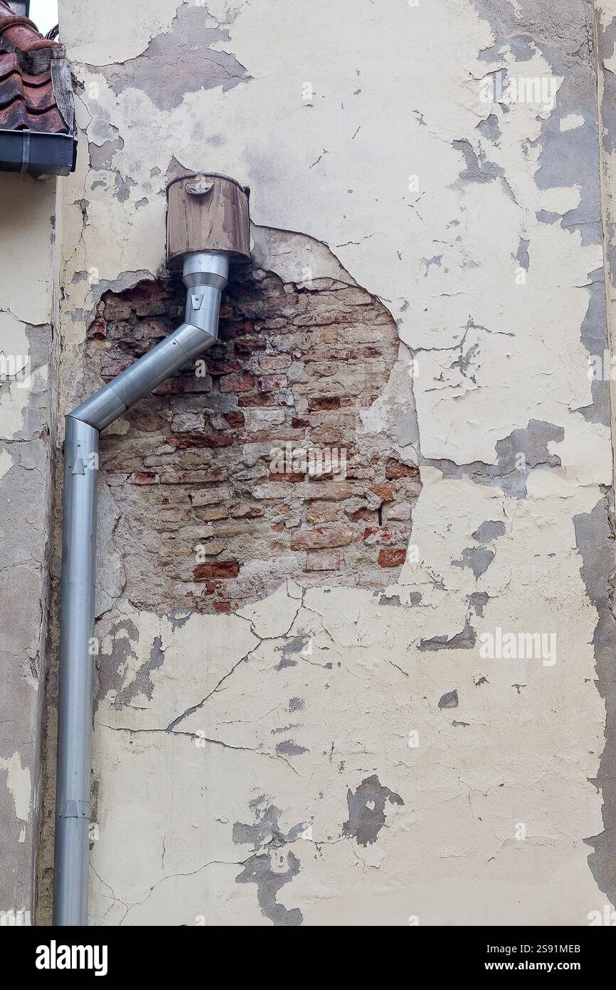 A fragment of the wall of an old building with decayed plaster exposing ...