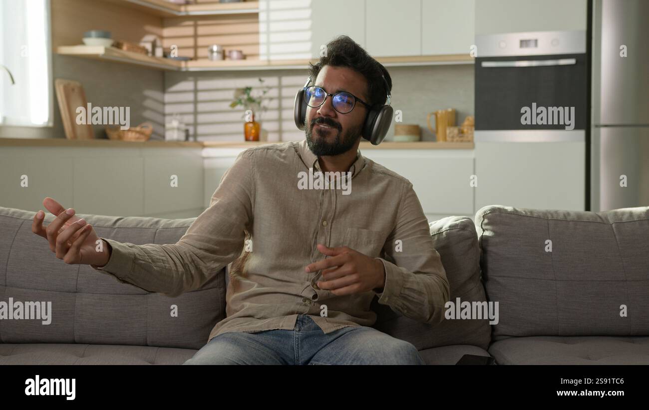 Happy relaxed Arabian man homeowner listen music in headphones enjoy ...