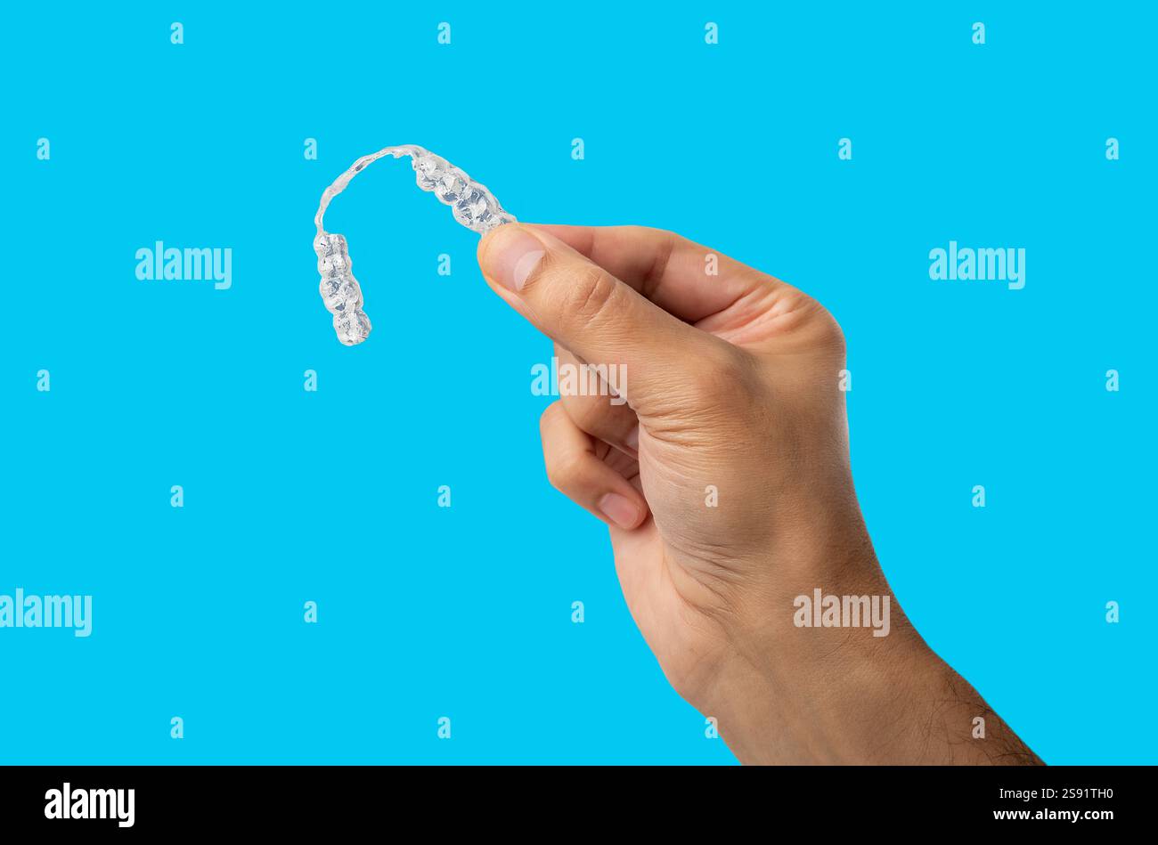 Male hand holding a worn and broken silicone trainer with blue ...