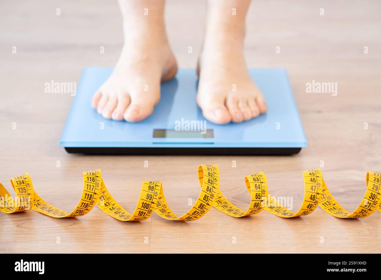 Tape measure and woman feet standing on weigh scales.Diet, weight loss ...