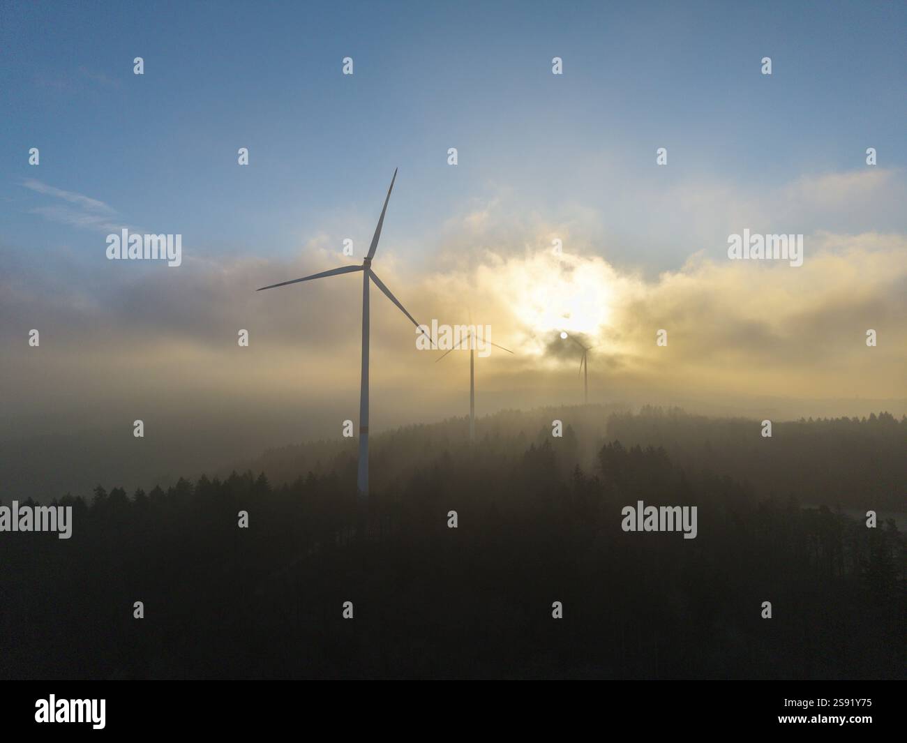 Wind turbines in the morning fog with sunlight breaking through, Rems ...