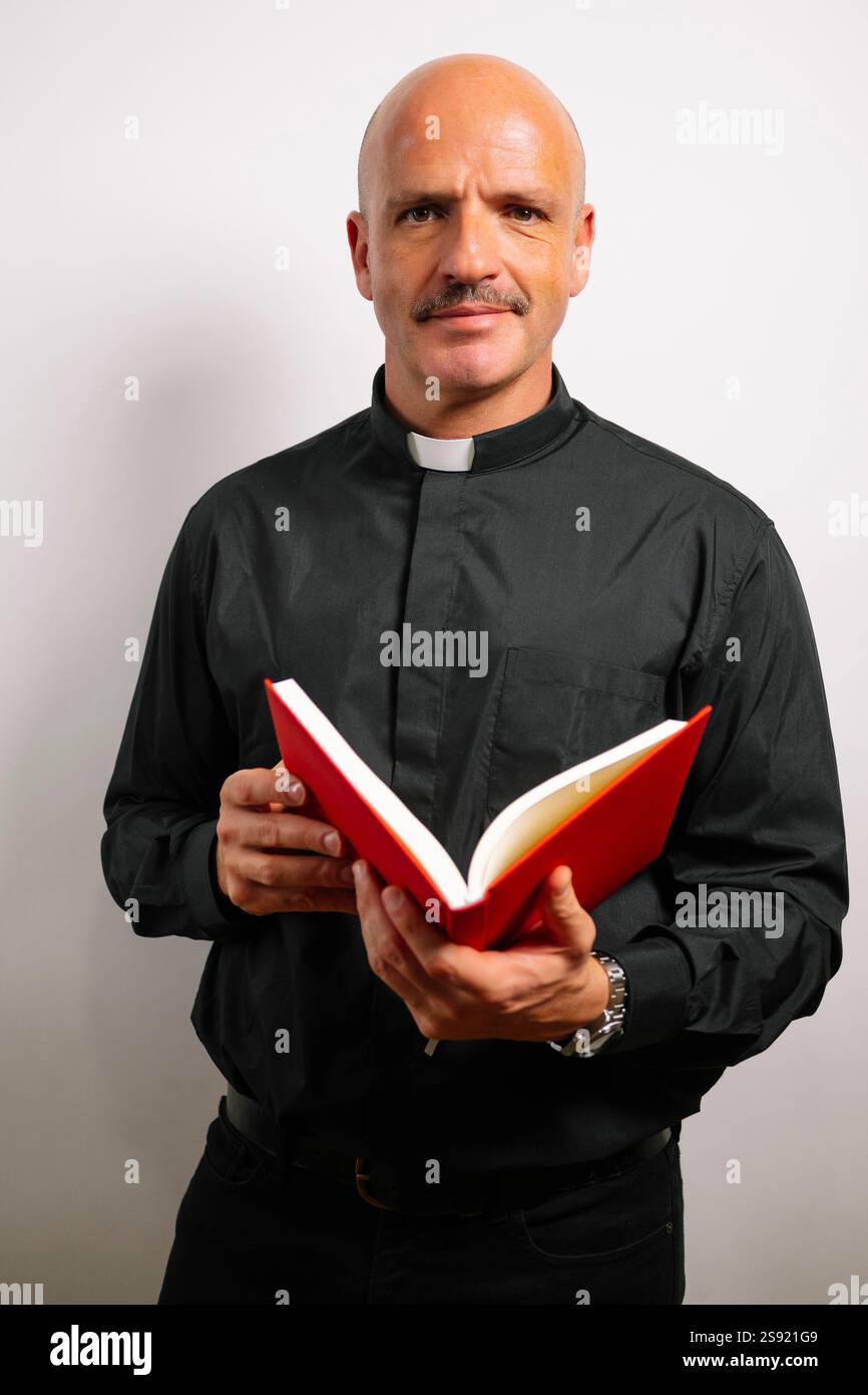 Portrait of a priest holding a bible Stock Photo - Alamy