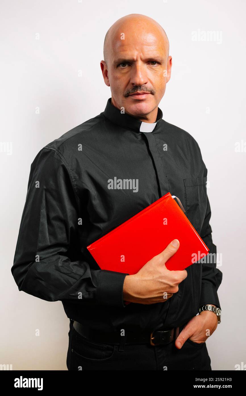 Portrait of a priest holding a bible Stock Photo - Alamy