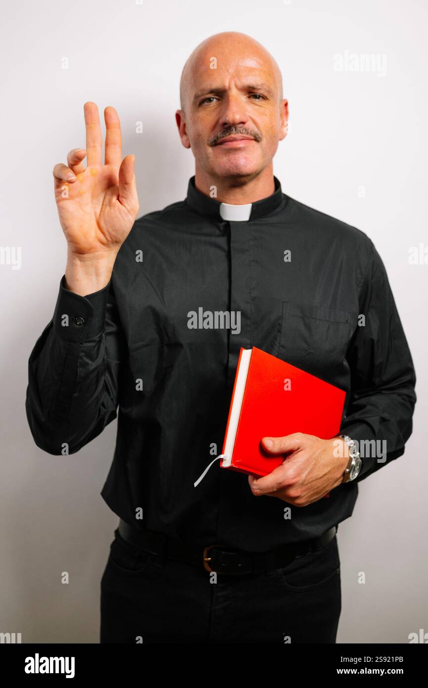 Portrait of a priest holding a bible Stock Photo - Alamy