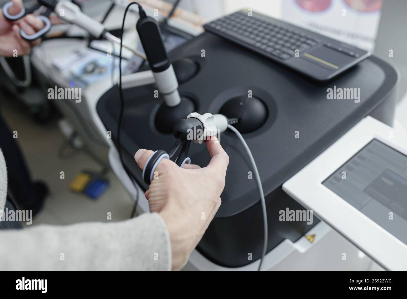 Hands operating a medical device with black control handles Stock Photo ...