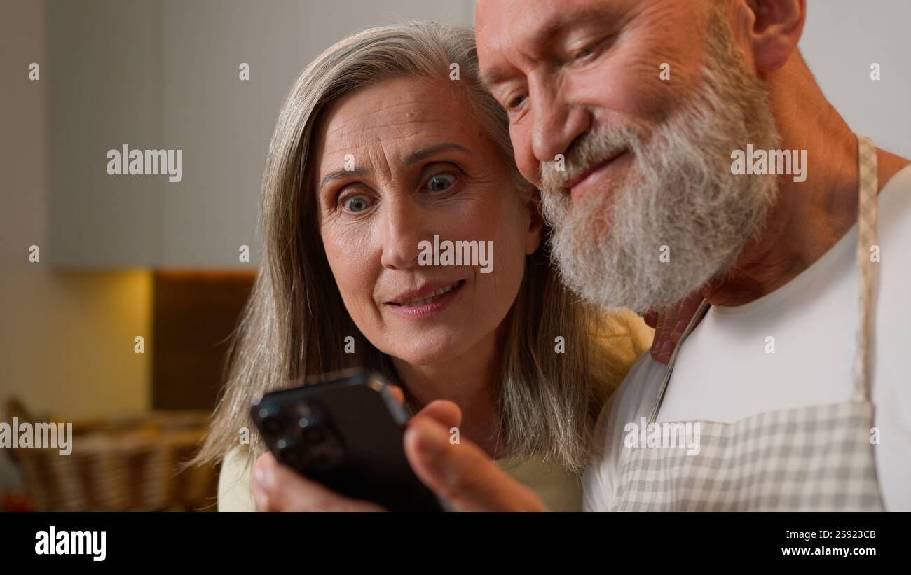 Close up happy old senior Caucasian family laughing in kitchen bonding ...