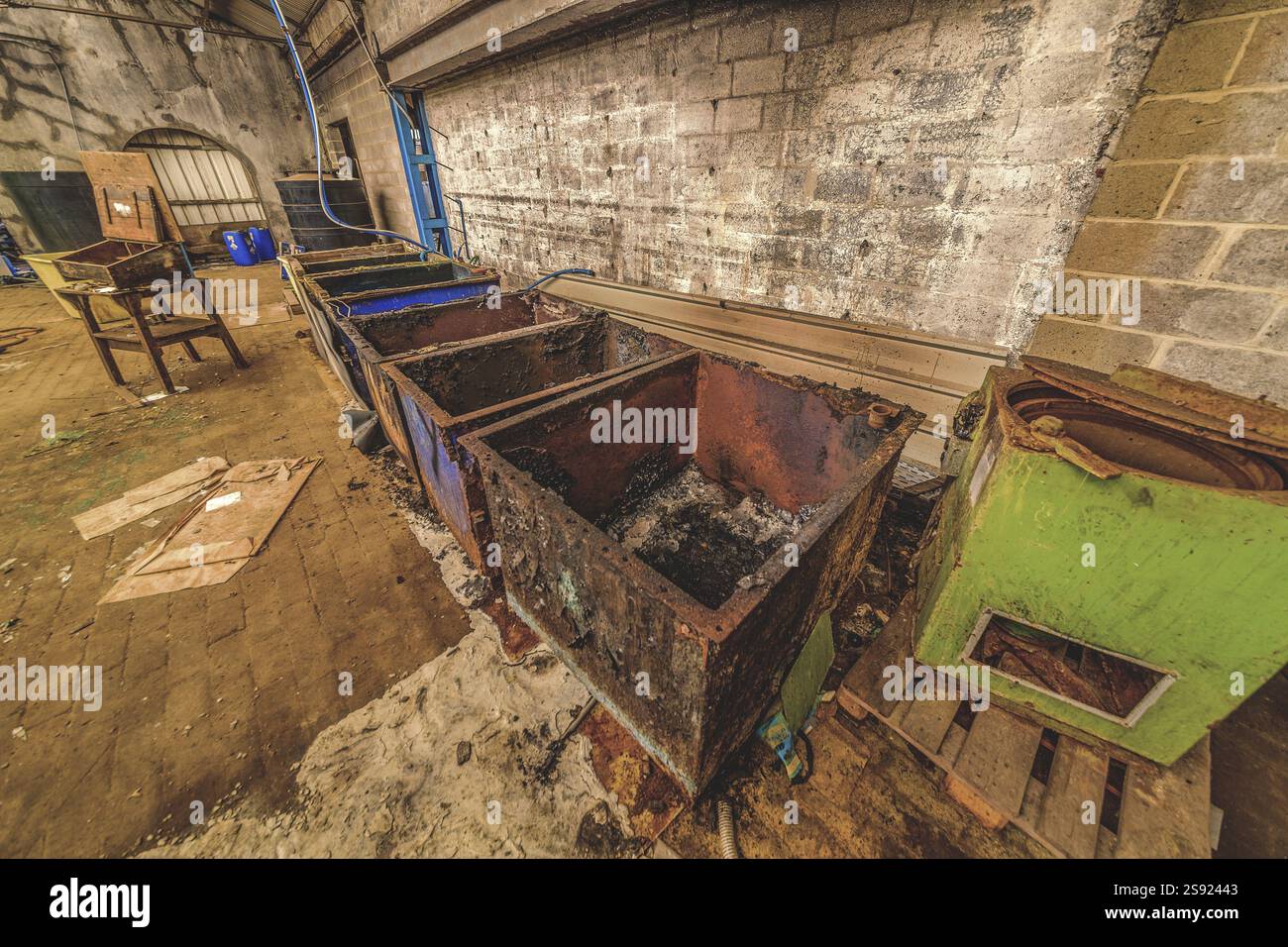Rusted containers in an old, dilapidated workshop with an industrial ...
