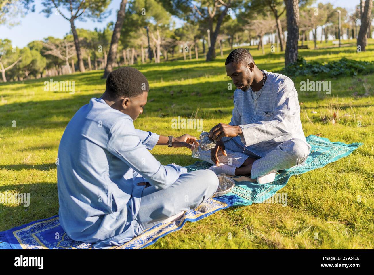 Two senegalese men in traditional dress enjoying a peaceful moment in a ...