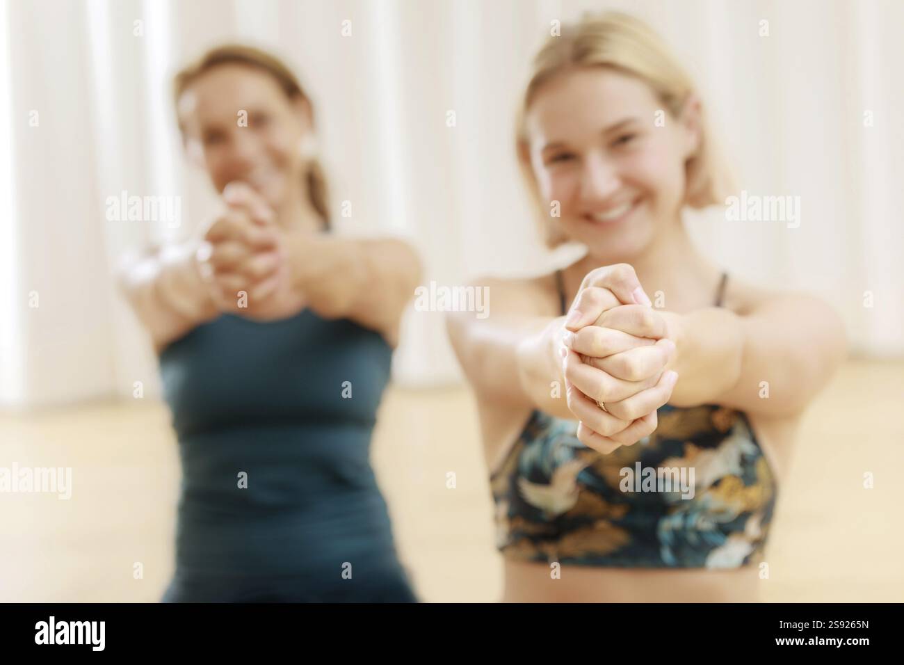 An image of a yoga class hands stretching at the front Stock Photo - Alamy