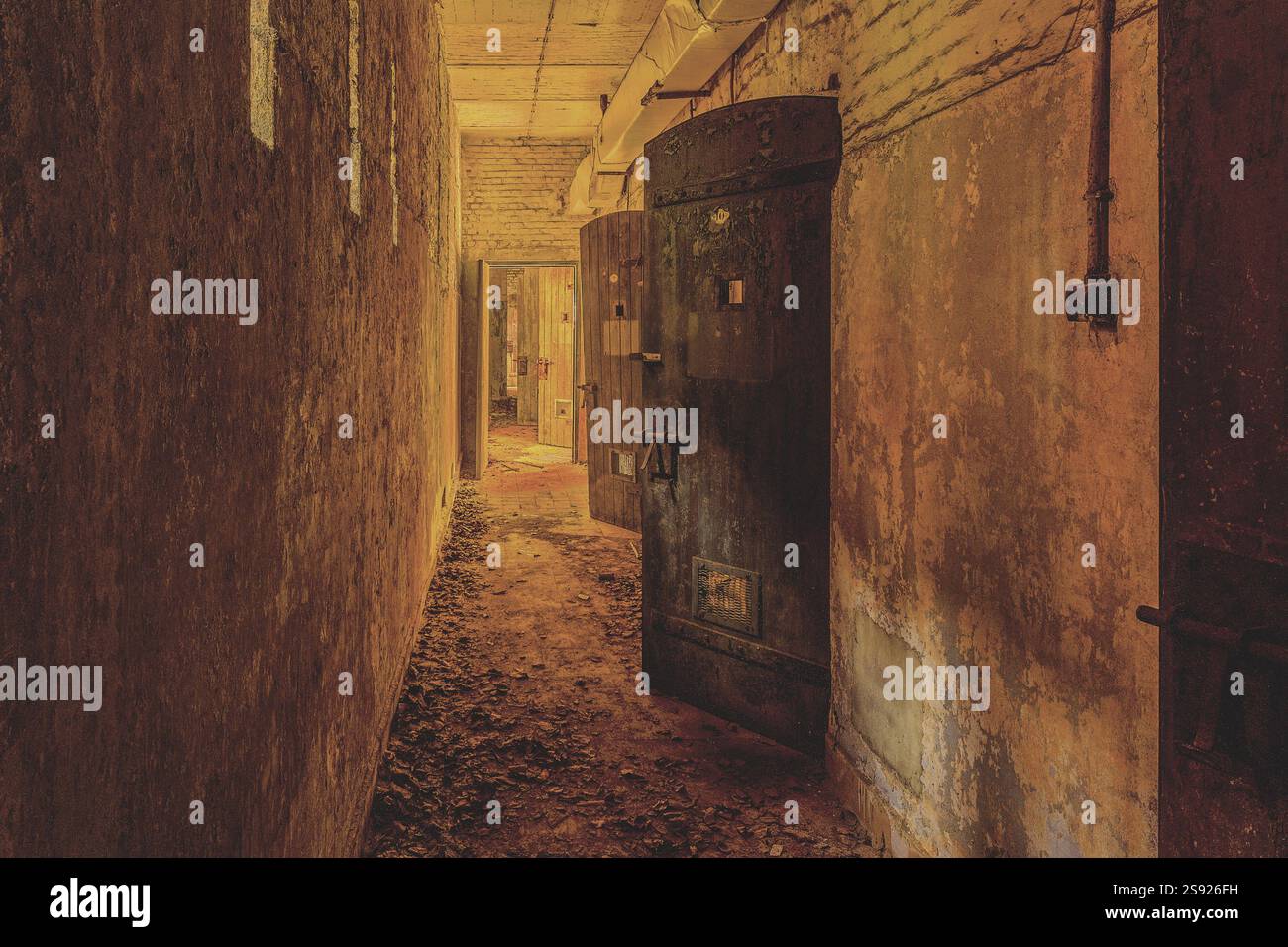 Long, dark corridor with open doors and dilapidated walls, Prison H11 ...