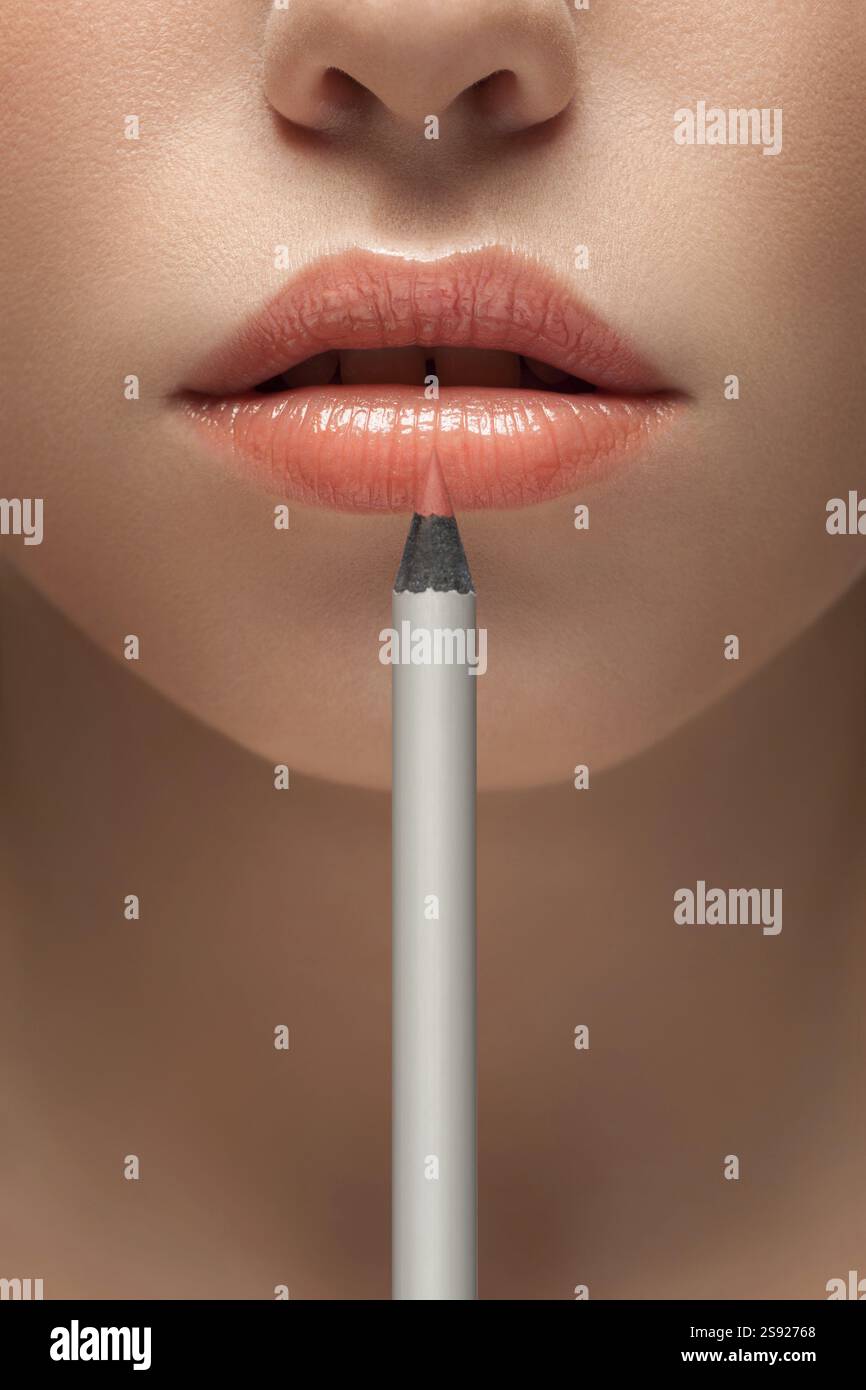 A sensual image of the woman's lower face with make-up pencil in front ...