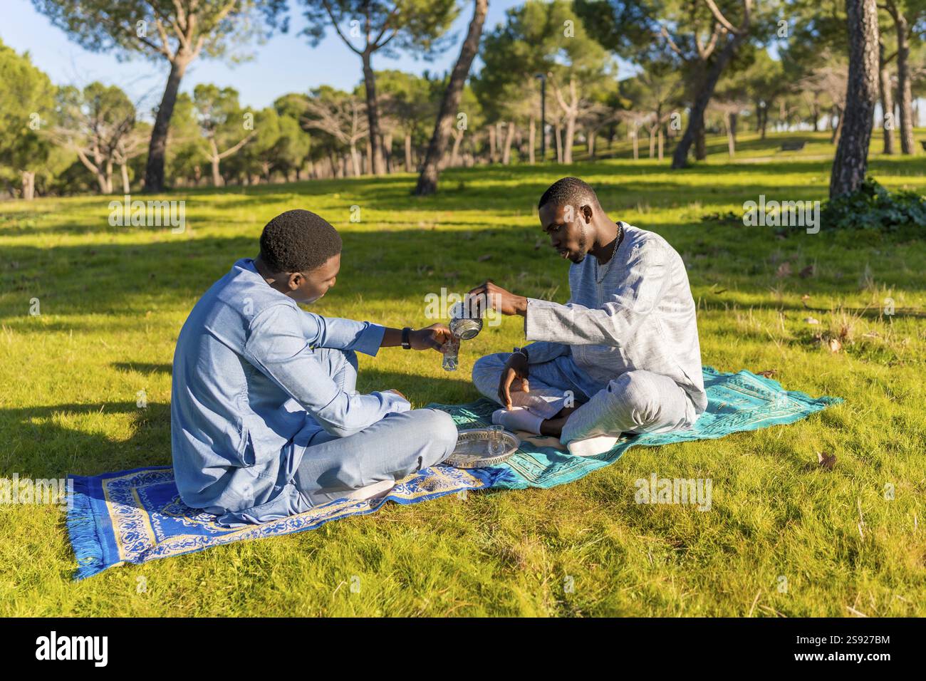 Two senegalese men in traditional dashiki clothing are sitting on a ...