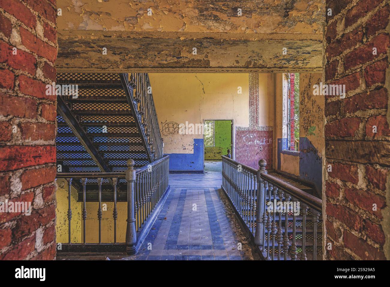 Dilapidated stairwell in an abandoned building with red brick walls ...