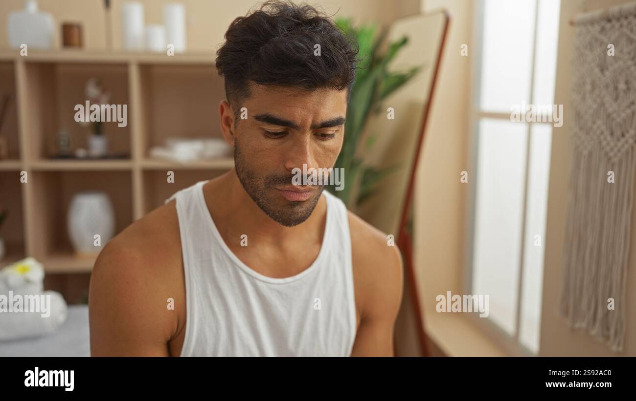Handsome young hispanic man sitting indoors in a spa wellness center ...