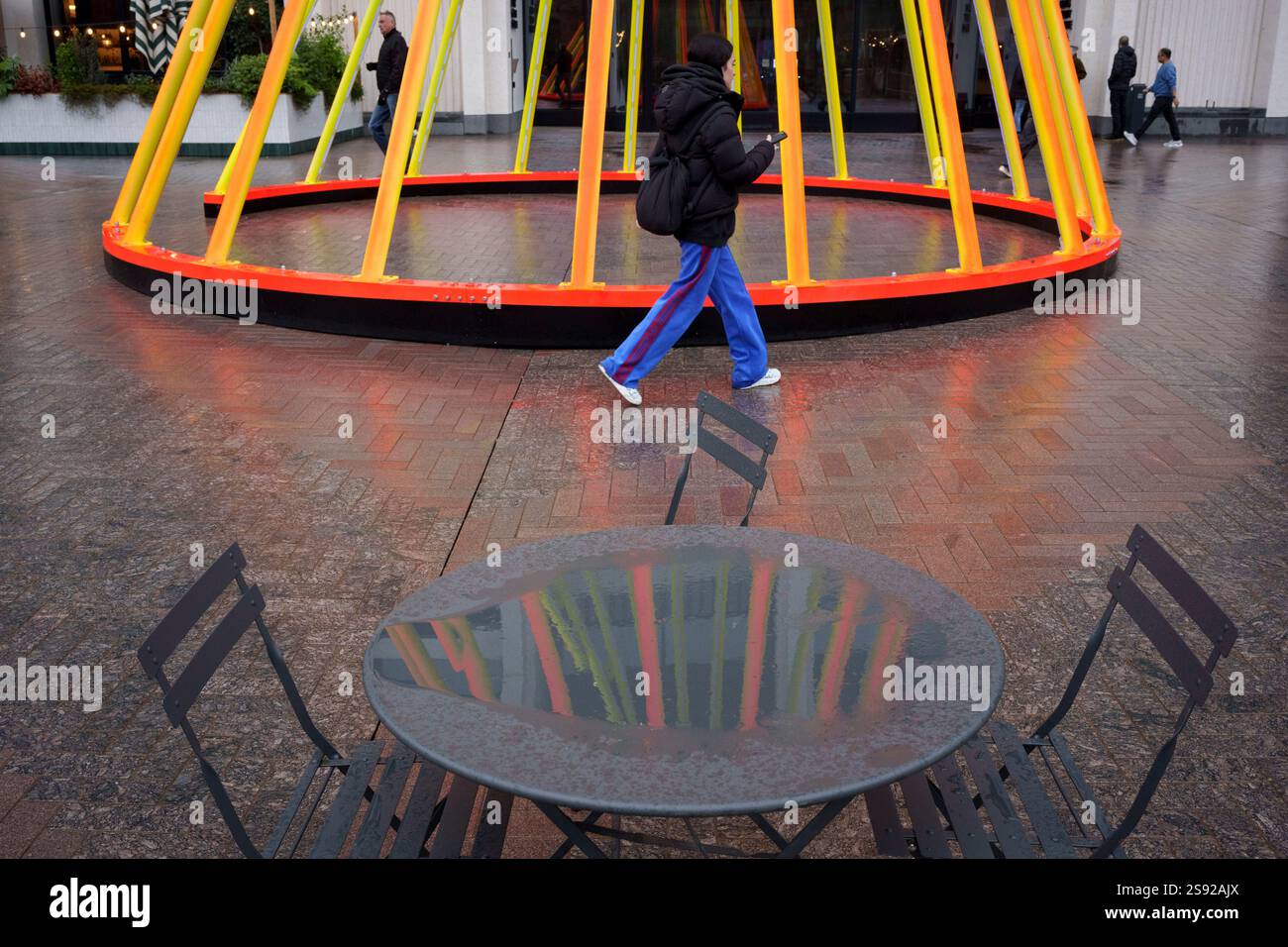 Members of the public pass an illuminated sculpture at Lewis Cubitt ...