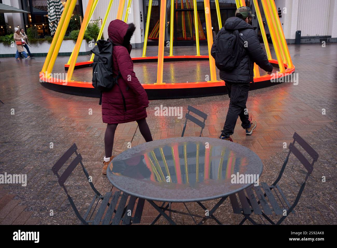 Members of the public pass an illuminated sculpture at Lewis Cubitt ...