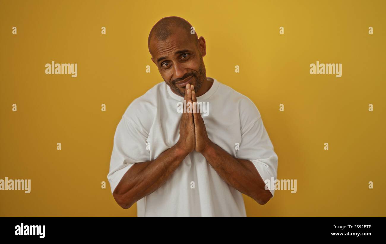 Handsome young african american man making a please gesture with his hands together, isolated ...
