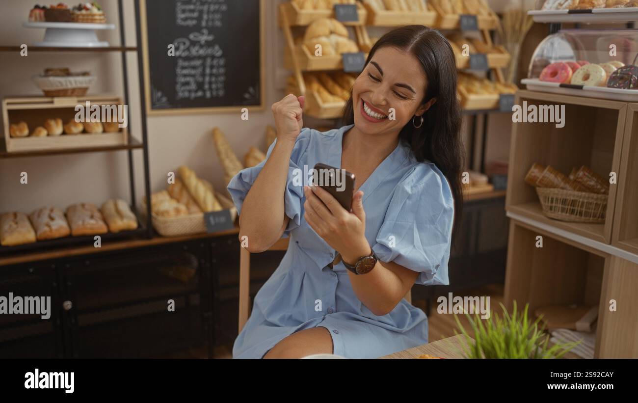 Young woman celebrates good news while using her phone in a beautiful ...