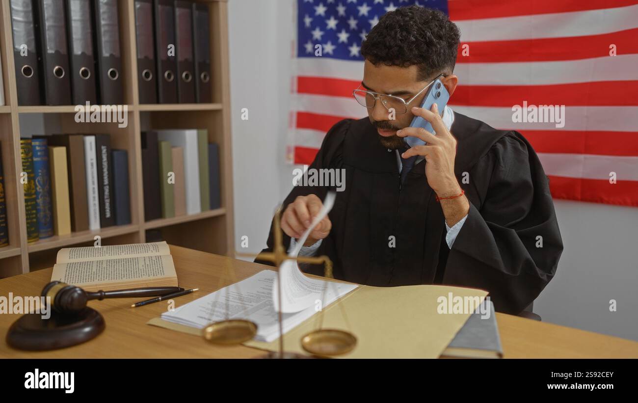Young man in courtroom reviewing documents while talking on phone with ...
