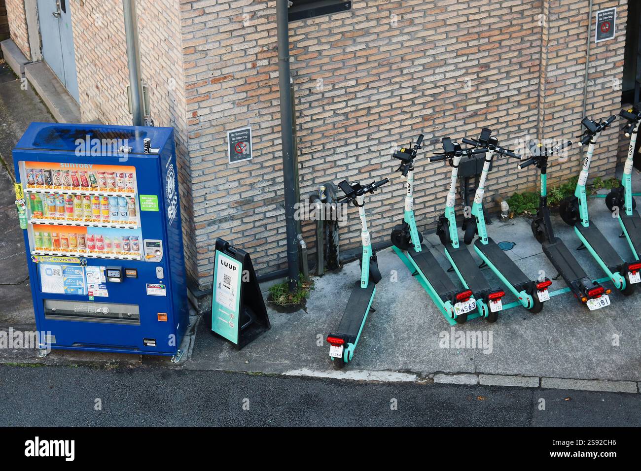 TOKYO, JAPAN - January 21, 2025: A row of parked Luup rental e-scooters ...