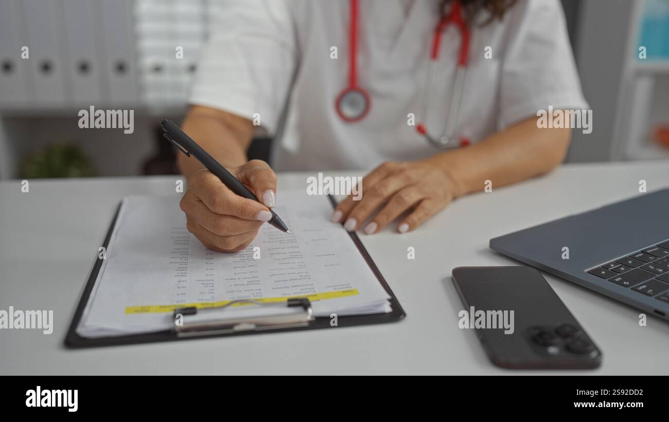 Woman writing notes with pen in clinic office showing mature female in ...