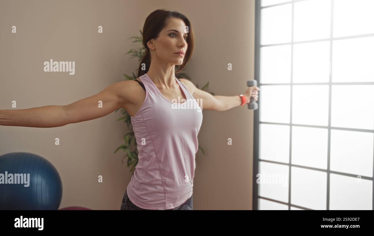 Woman exercising indoors with weights, showcasing determination and ...