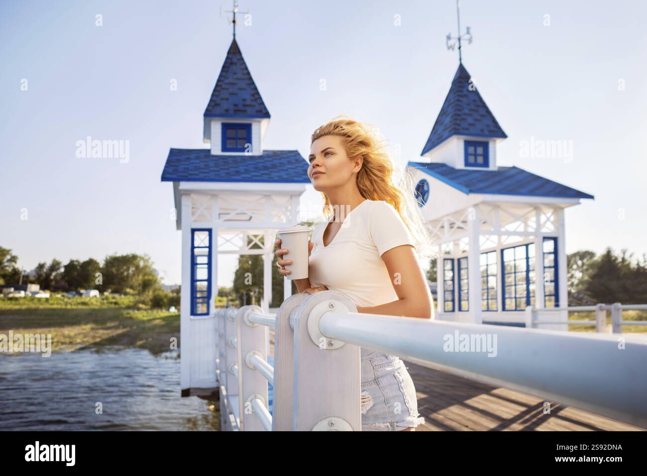 Beautiful young woman with a cup of coffee to go, standing on the ...