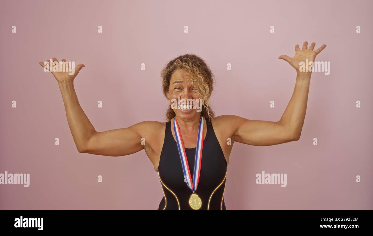 Woman victoriously raising arms up against isolated pink background ...