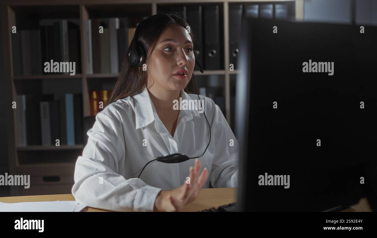 Hispanic woman in an office wearing a headset, engaged in communication ...