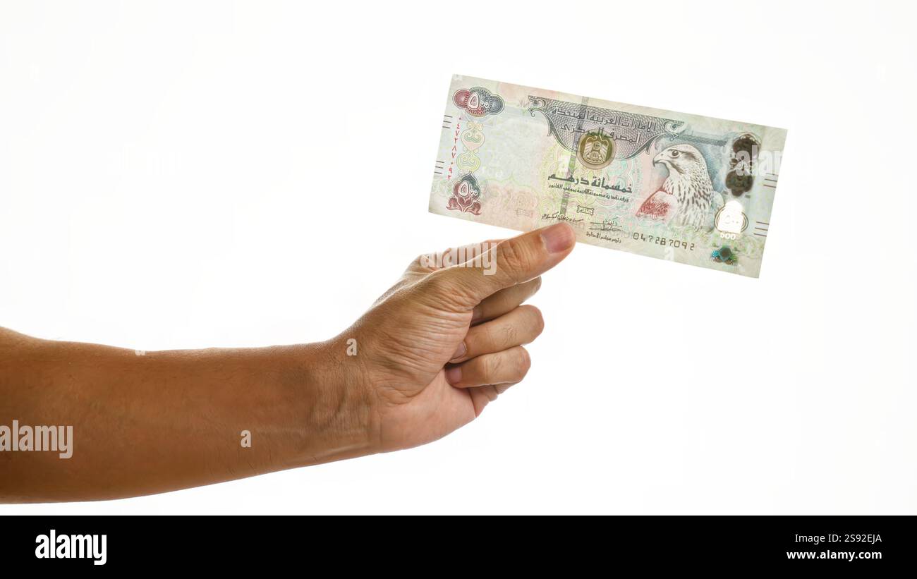 Hand holding uae dirham currency note isolated against a white ...