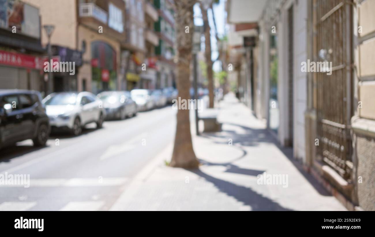 Blurred street view with cars parked alongside shops and buildings on a ...