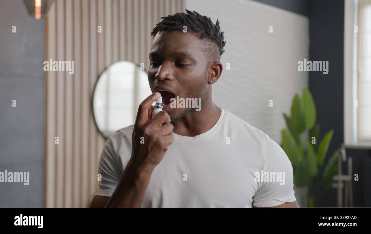 African American ethnic man applying fresh breath spray prevent stink ...
