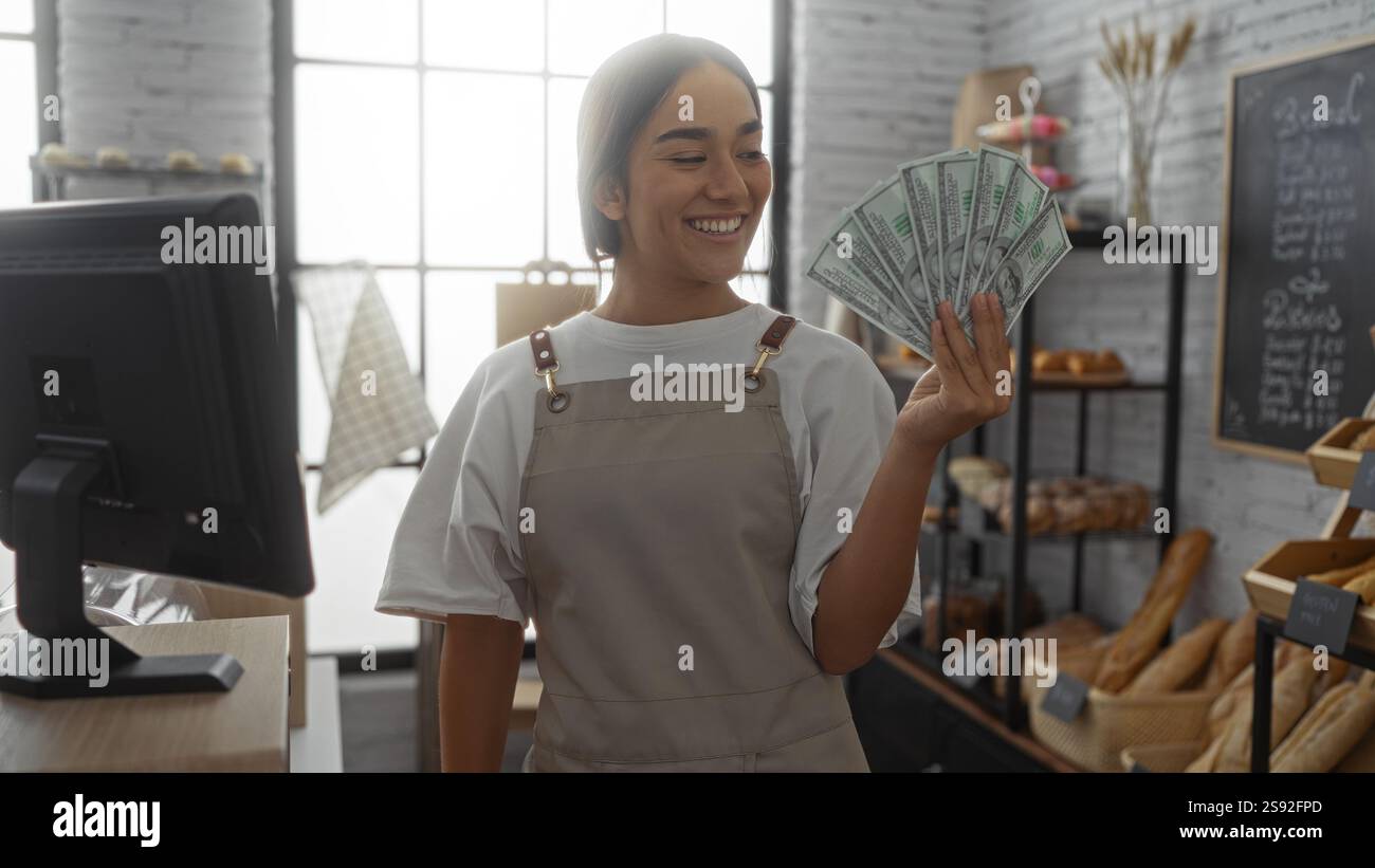 Brunette woman in a bakery shop smiling while holding money in her hand ...
