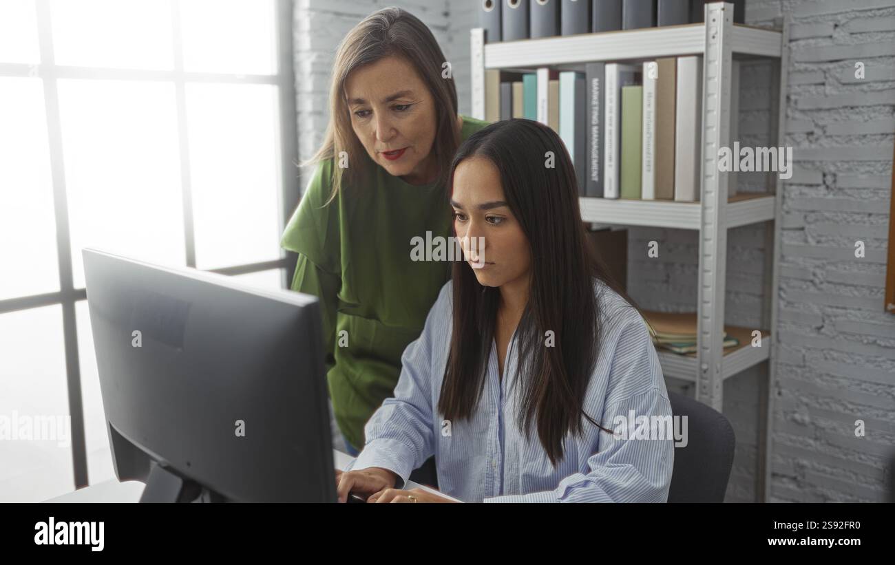 Women working together in an office, with one woman in a green shirt ...