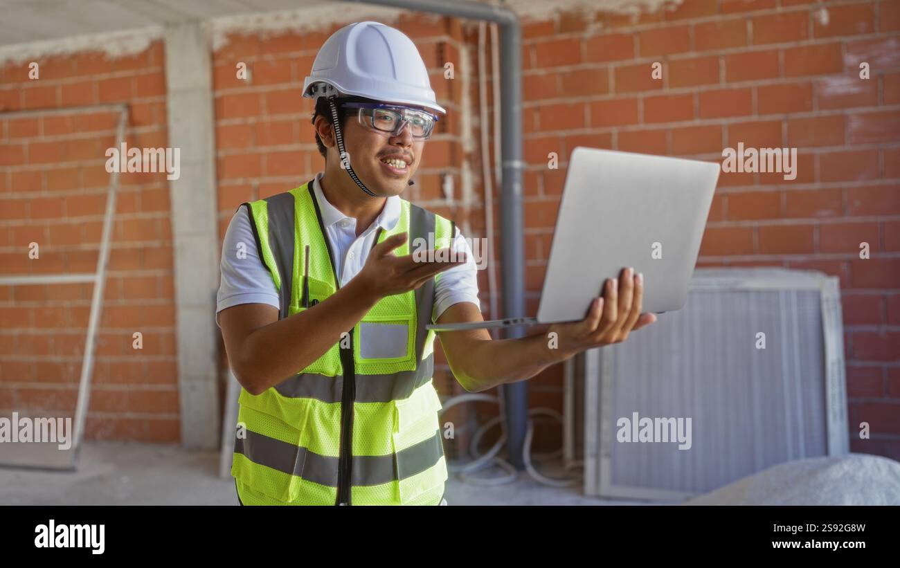 Young male construction worker wearing a hard hat and safety vest ...