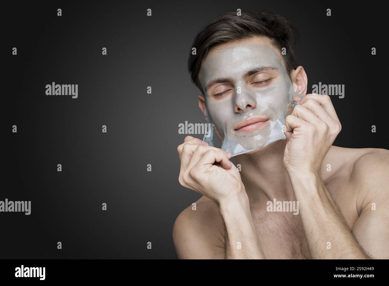 Portrait of a handsome young man removing a face mask, face and body ...