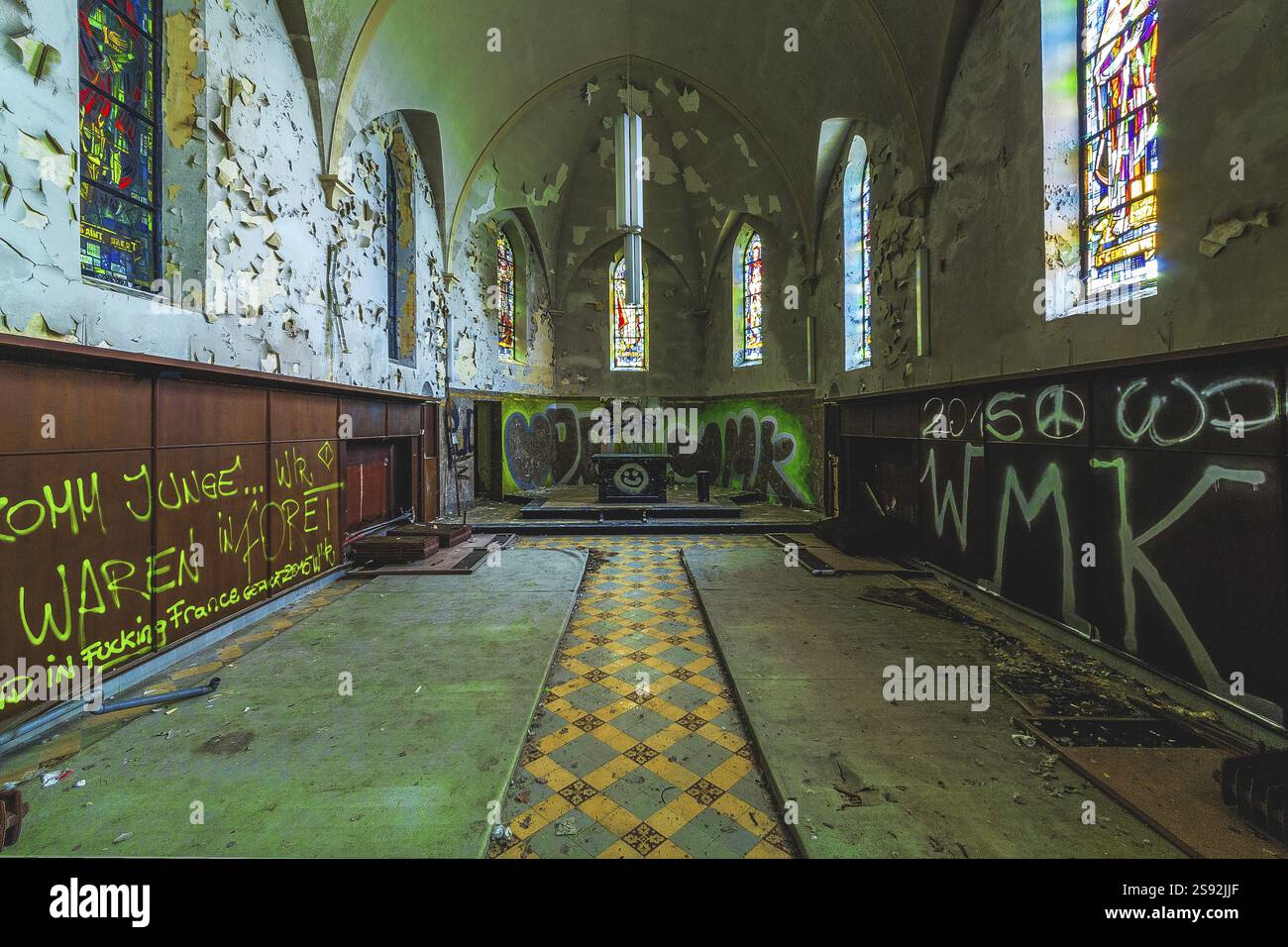Abandoned church with graffiti on the walls and stained glass windows ...