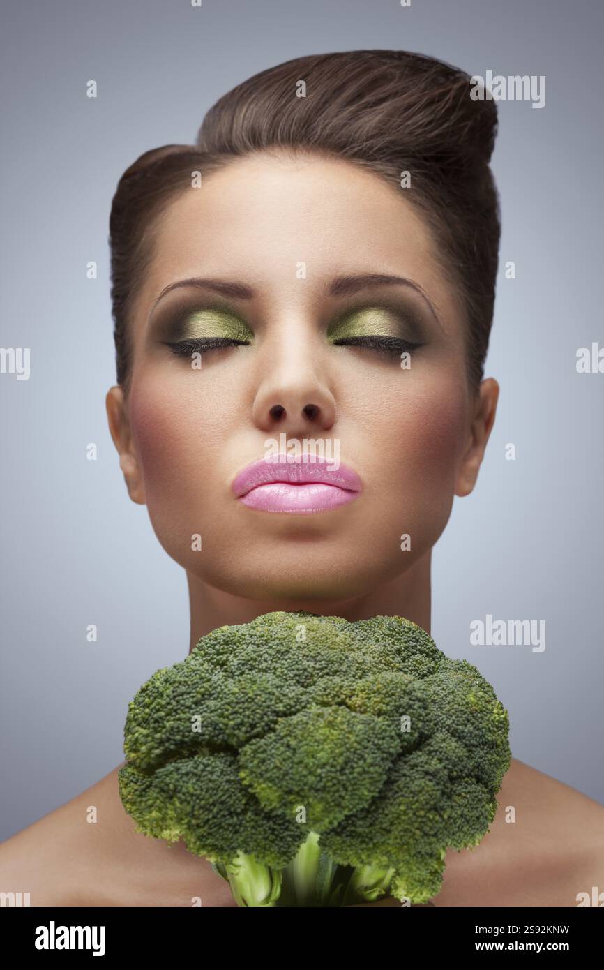 The sweet photo of the beauty with broccoli in front of her neck Stock ...
