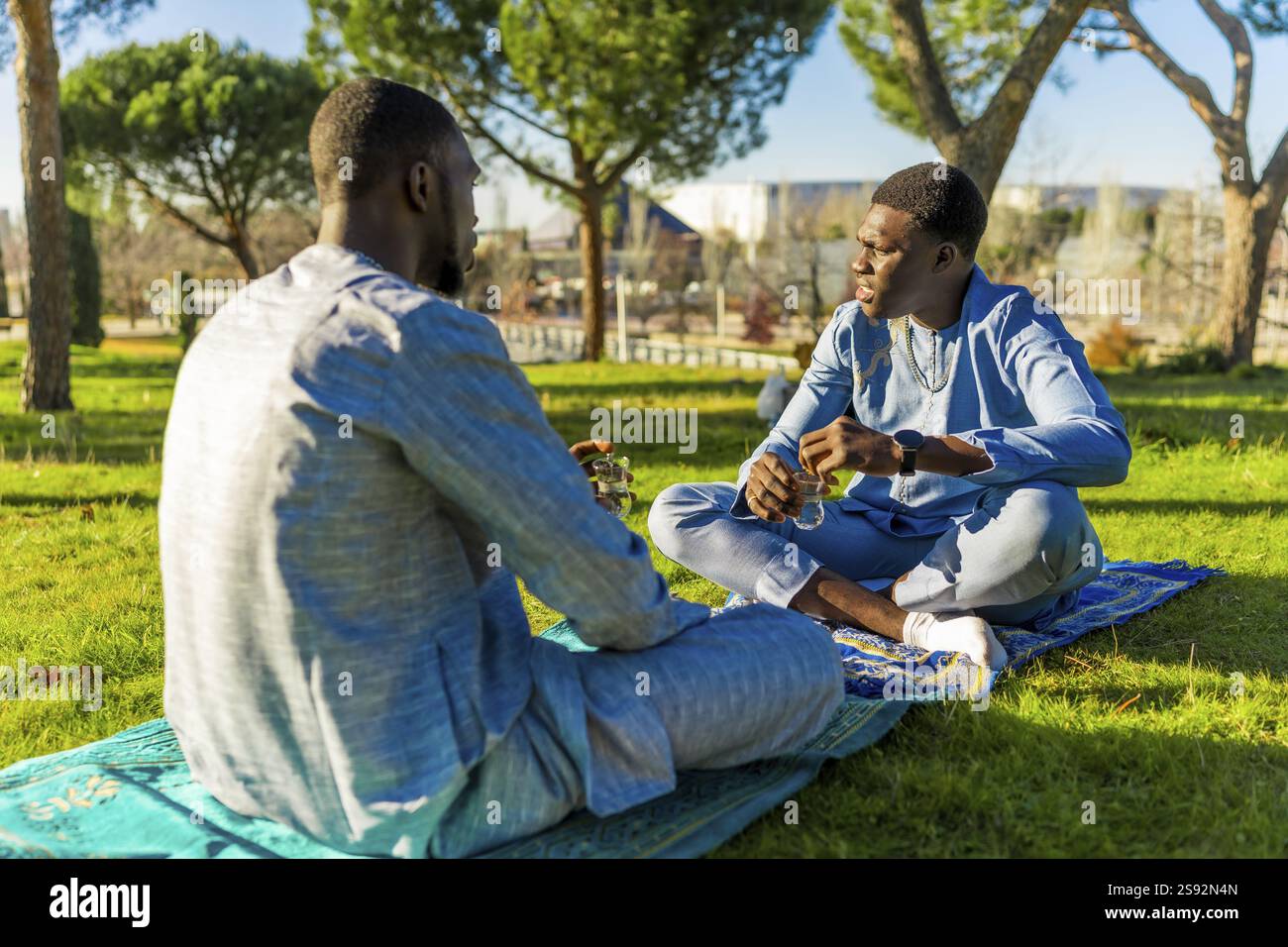 Two senegalese men wearing traditional dashiki clothing are enjoying ...