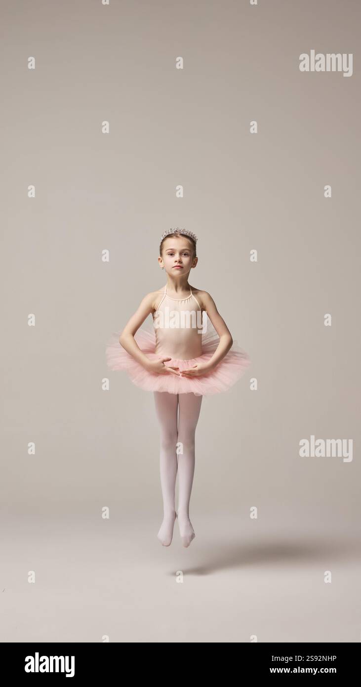 Girl in pink tutu and tiara in mid-air jump with pointed toes and ...