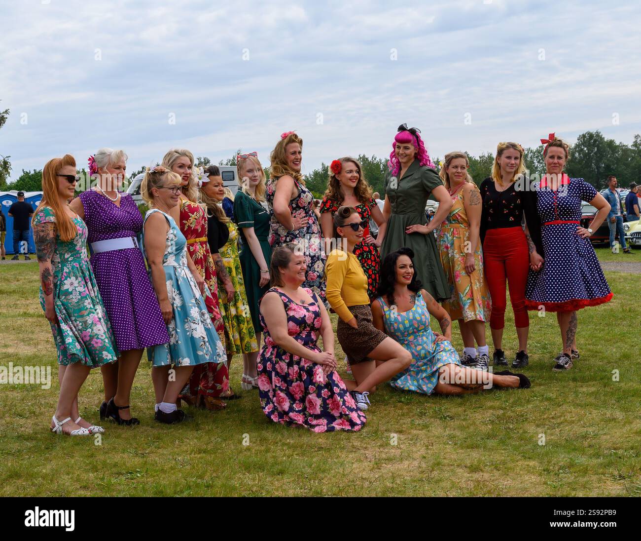 A joyful group of women dressed in colorful vintage attire are smiling ...