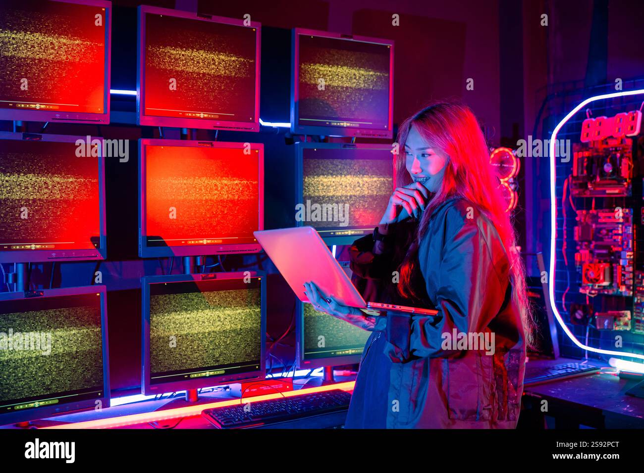 Asian woman holding laptop computer with CCTV room she check maintain ...